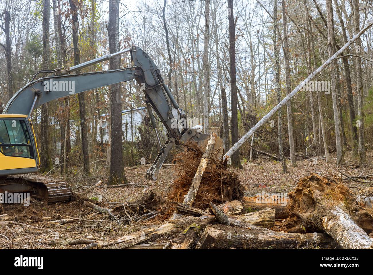 Excavator is being used by worker to clear land for house construction ...