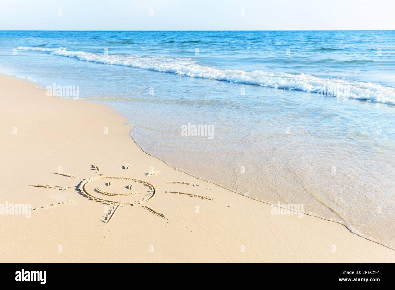 The drawing of the sun on sand beach with soft waves Stock Photo - Alamy
