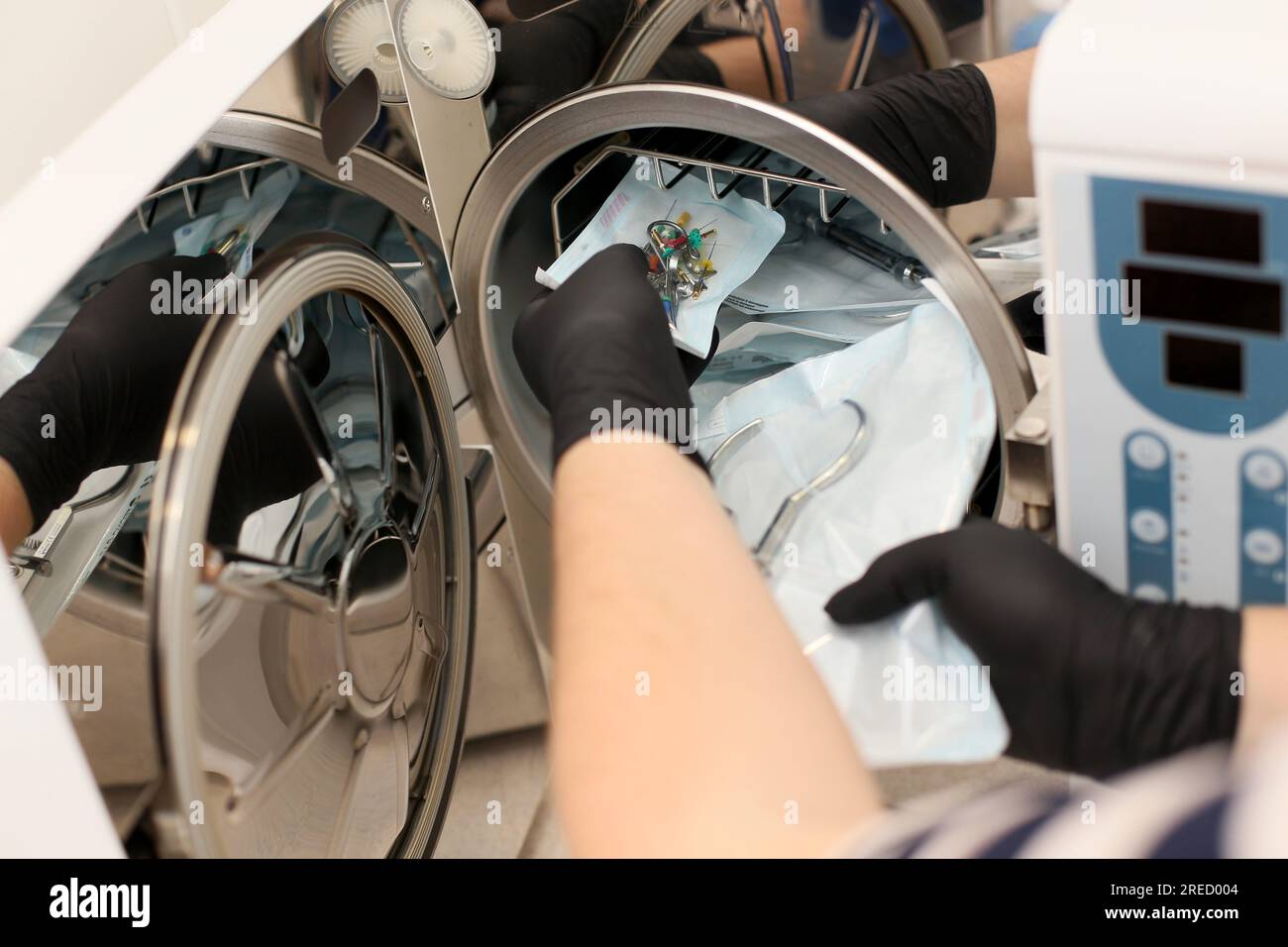 Hands in black gloves holding a medical instrument. Sterilizing box ...