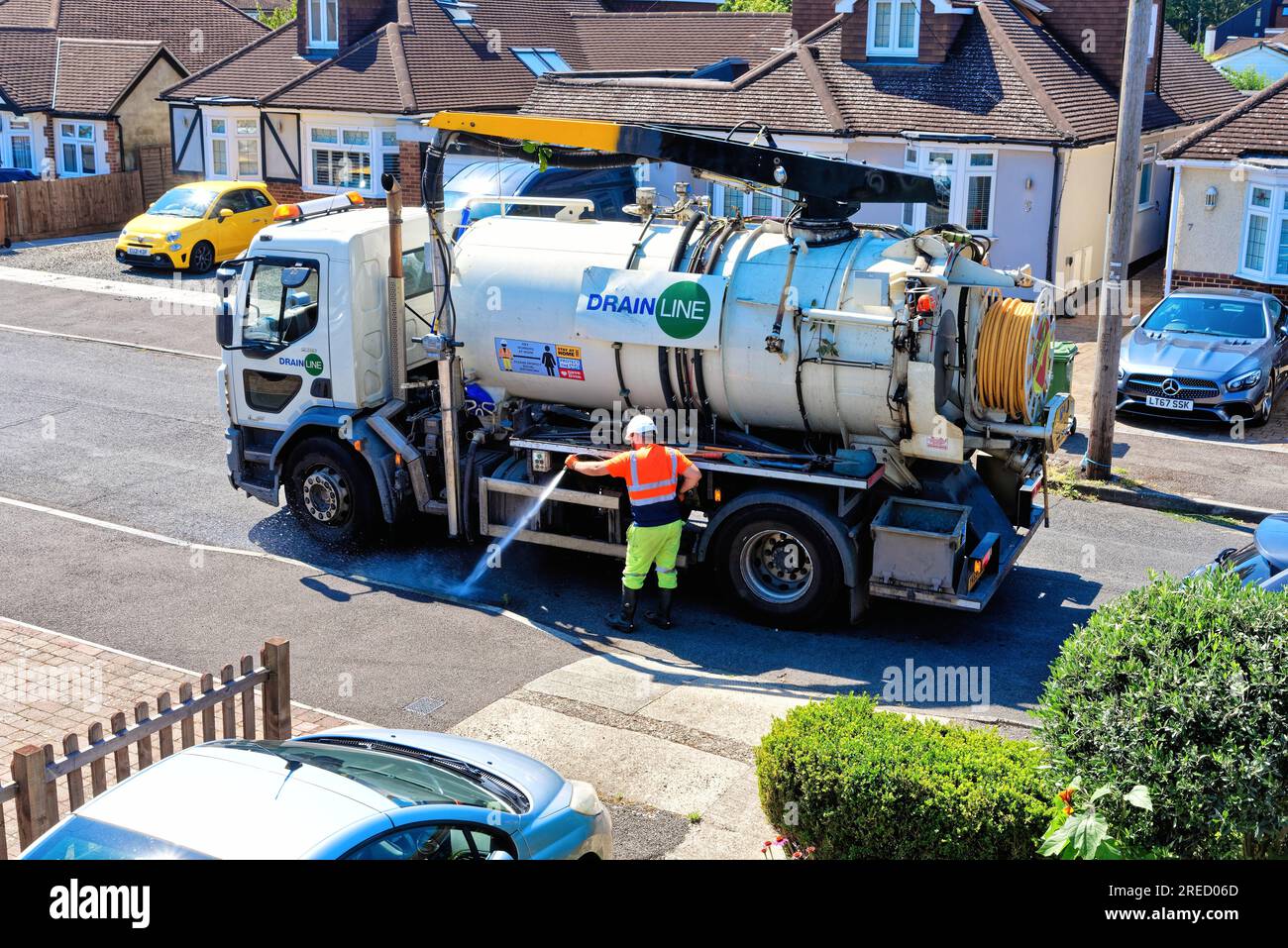 A Drainline suction lorry clearing a drain in a suburban road ...