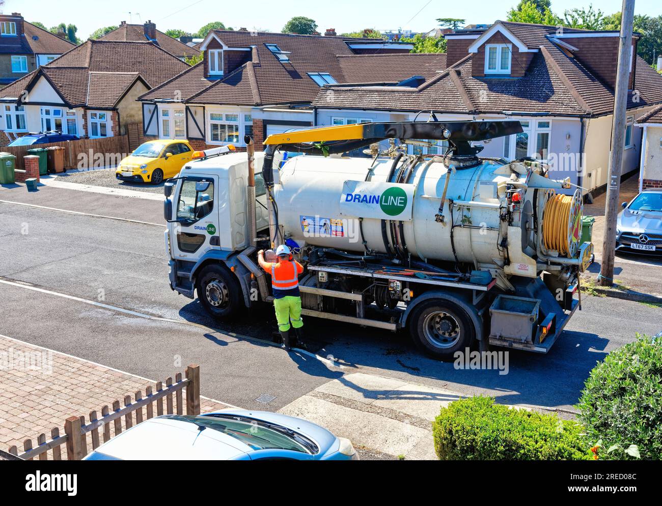 A Drainline suction lorry clearing a drain in a suburban road ...