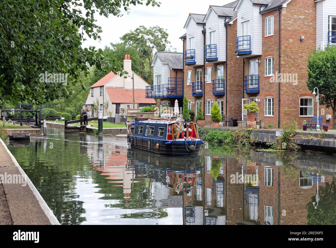 A small narrow boat exiting Thames Lock on the River Wey navigation ...