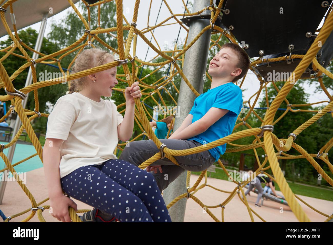 Boy and girl having fun at the ropes playground Stock Photo - Alamy