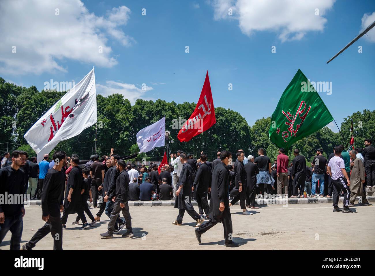 Shia Muslims walk with religious flags along a street during a ...