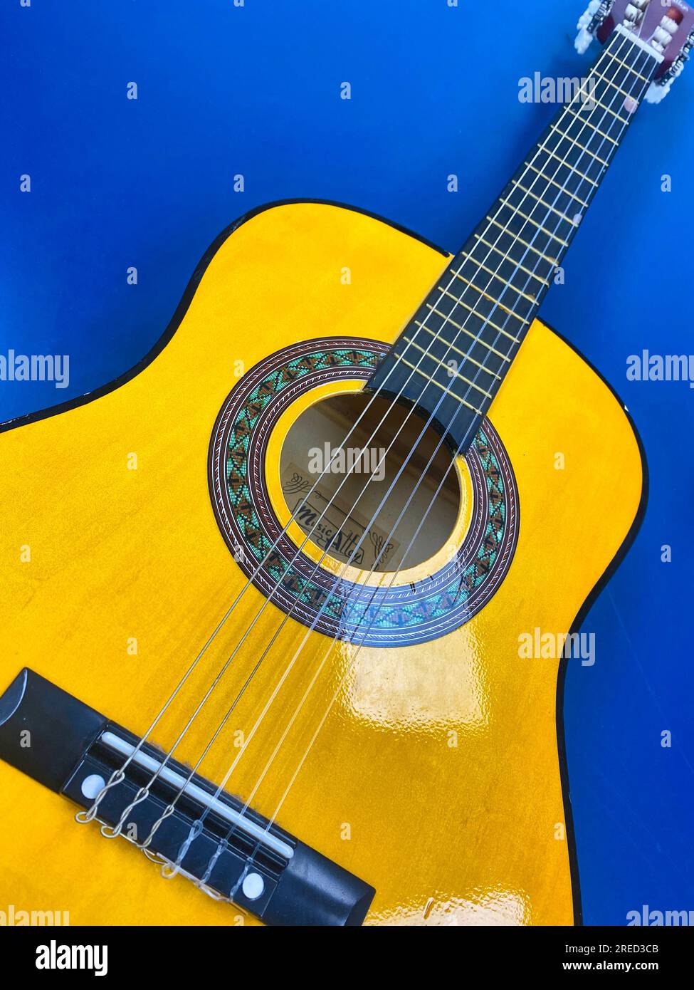 Acoustic guitar on a blue background Stock Photo - Alamy