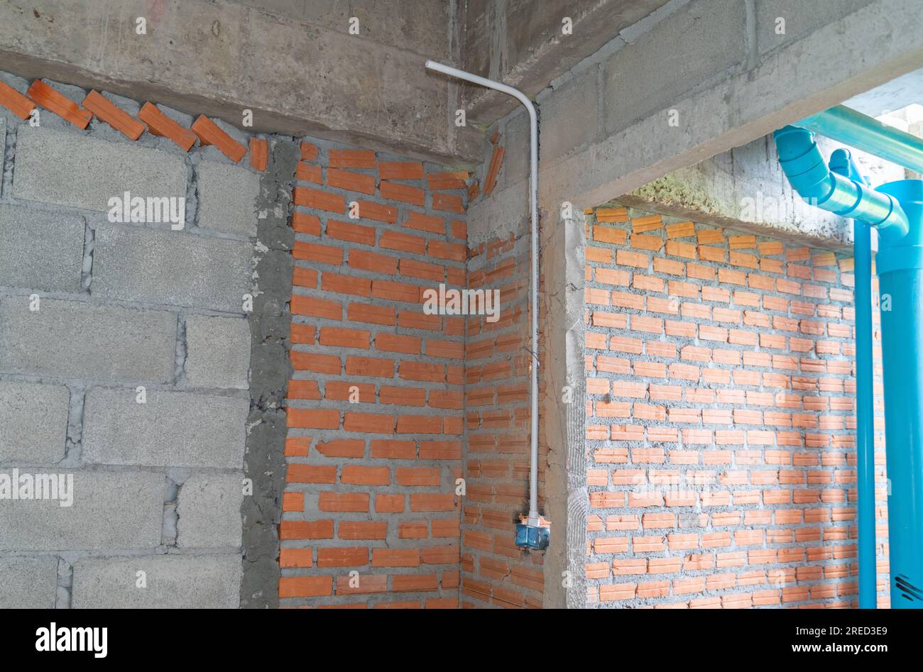Electrical conduit, and wires are installed in a house wall getting ...