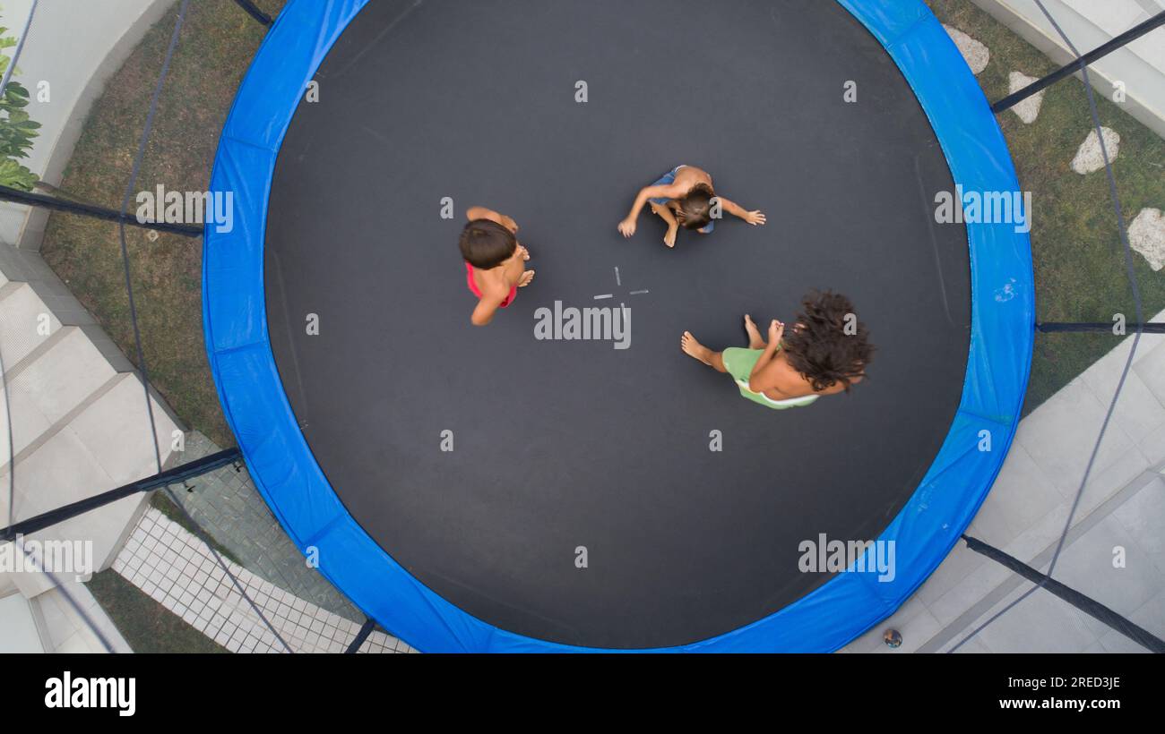 Children playing on trampoline aerial view together Stock Photo - Alamy