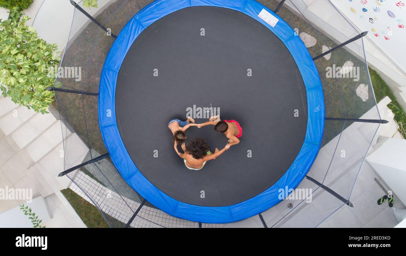 Children playing on trampoline aerial view together Stock Photo - Alamy
