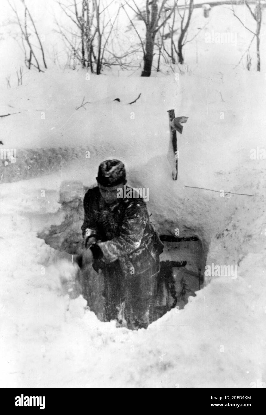 A German soldier shovels the entrance to the bunker free of snow in the ...