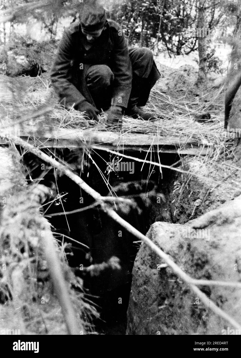 German soldiers cover their shelter with a layer of straw to provide ...