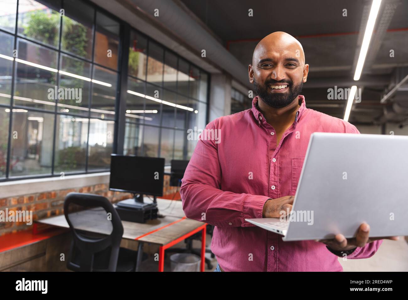 Portrait of indian man with a laptop smiling at office Stock Photo - Alamy