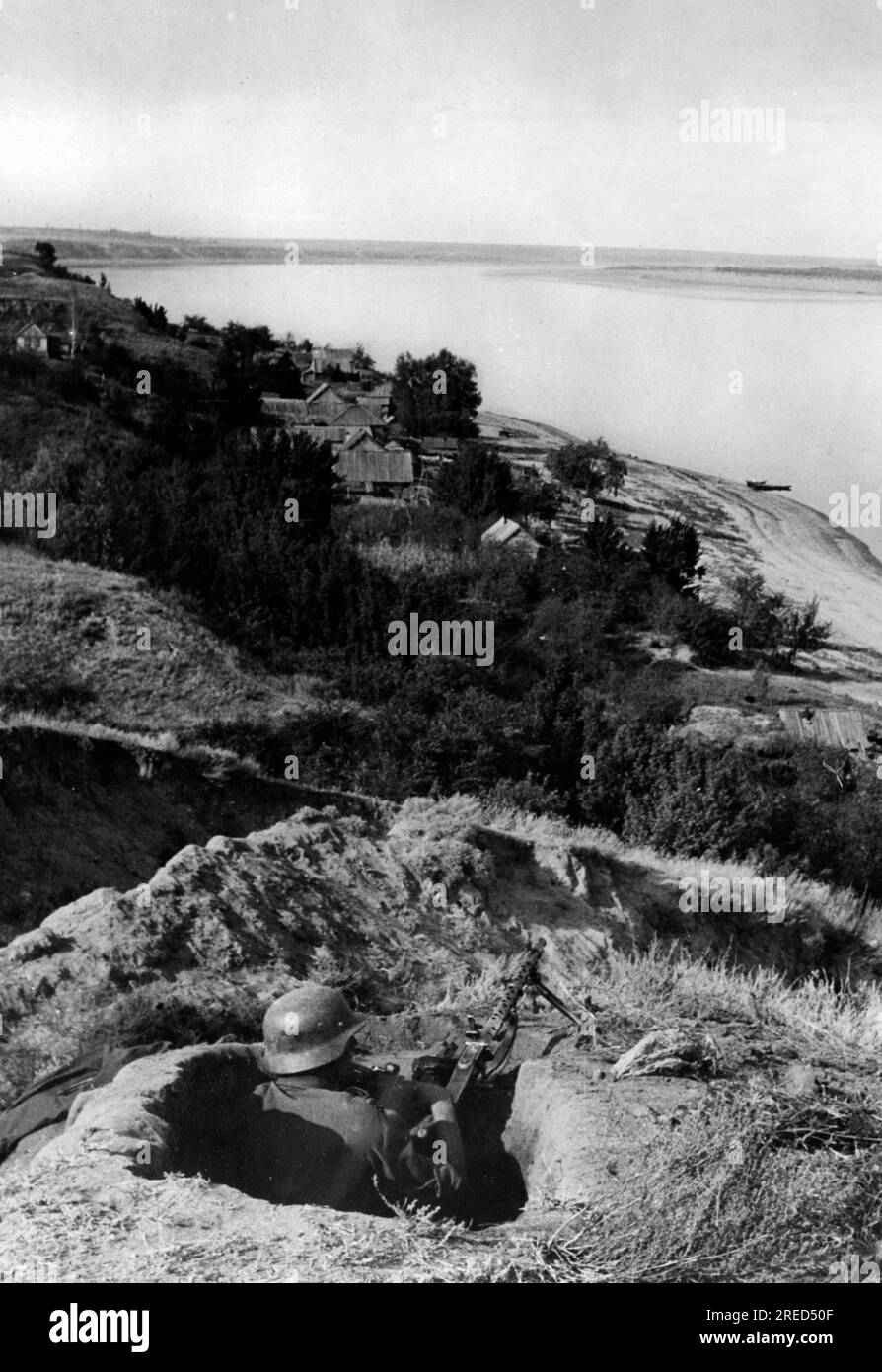 German soldier in his foxhole above a river course during the German ...