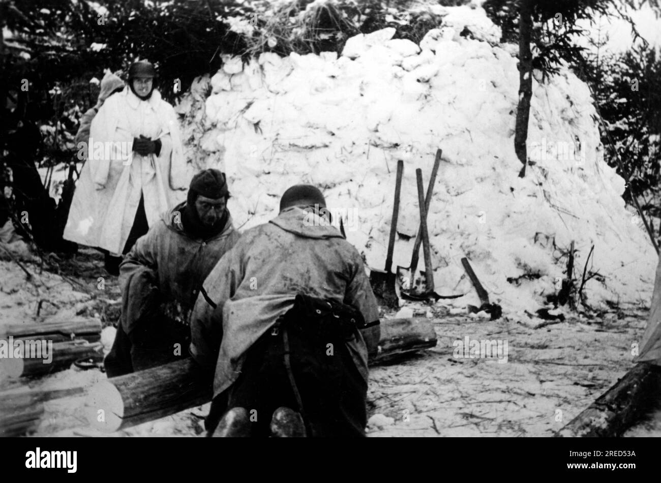 German soldiers are building a shelter. In the background, a simple ...