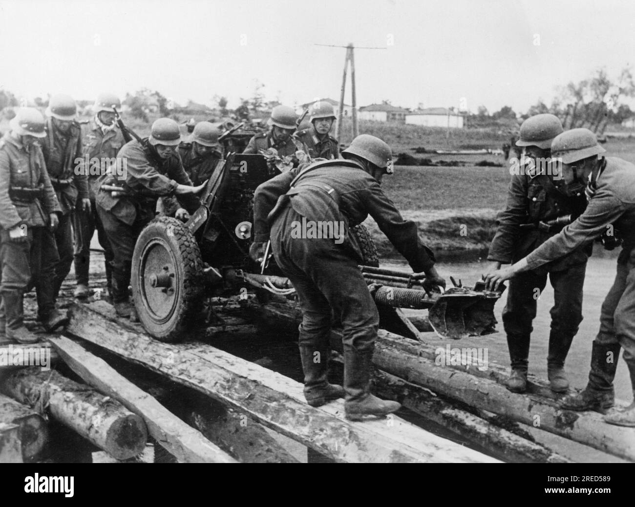German soldiers maneuver their 3.7cm pak 36 across a river east of Kiev ...
