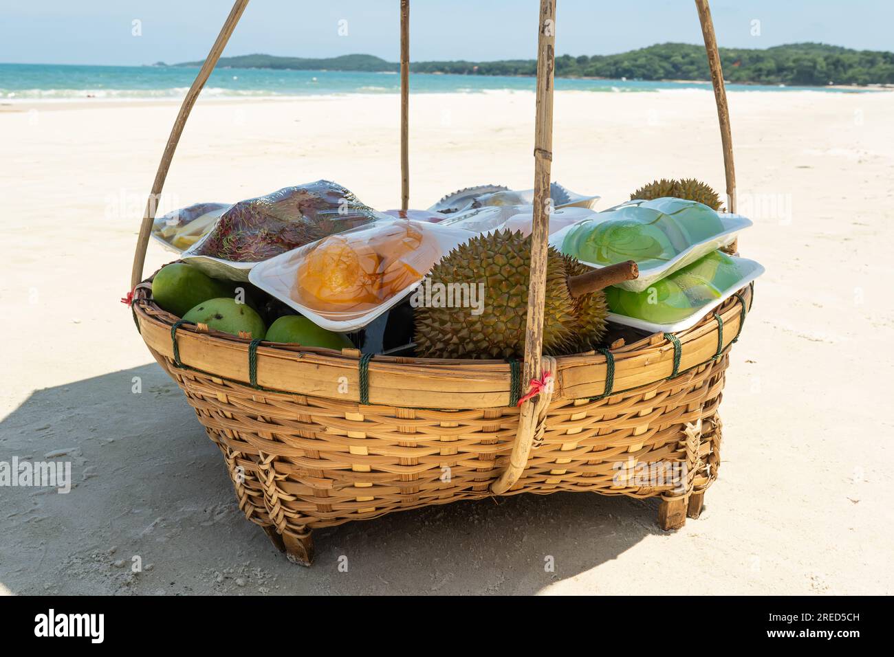 Fruits in a basket: durian , mango. A local beach vendor sells food to ...