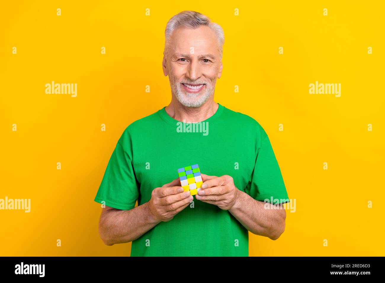 Portrait of positive clever aged person toothy smile arms hold rubik ...