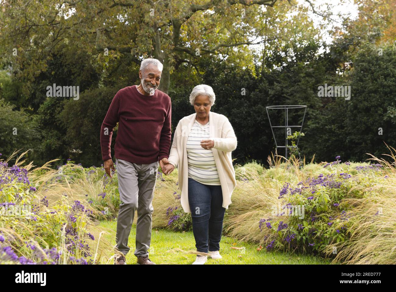 Happy senior biracial couple holding hands and walking in garden at home Stock Photo - Alamy