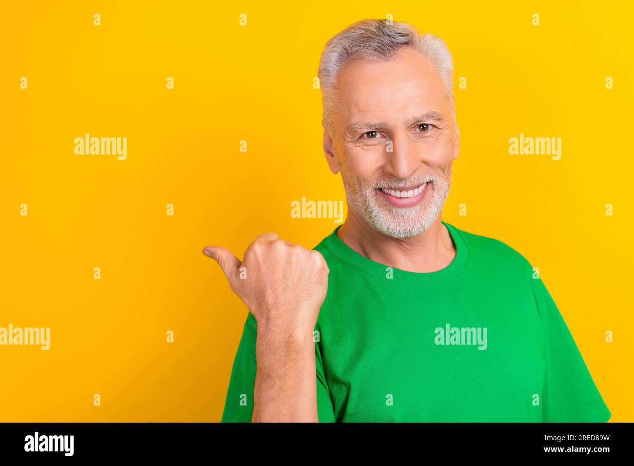 Photo of charming handsome guy dressed green t-shirt showing thumb back ...