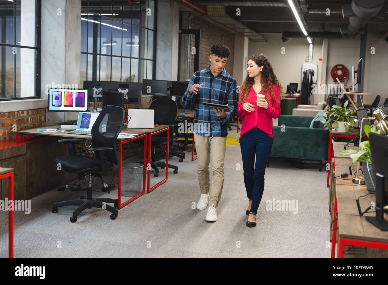 Busy diverse male and female colleagues walking through office having ...