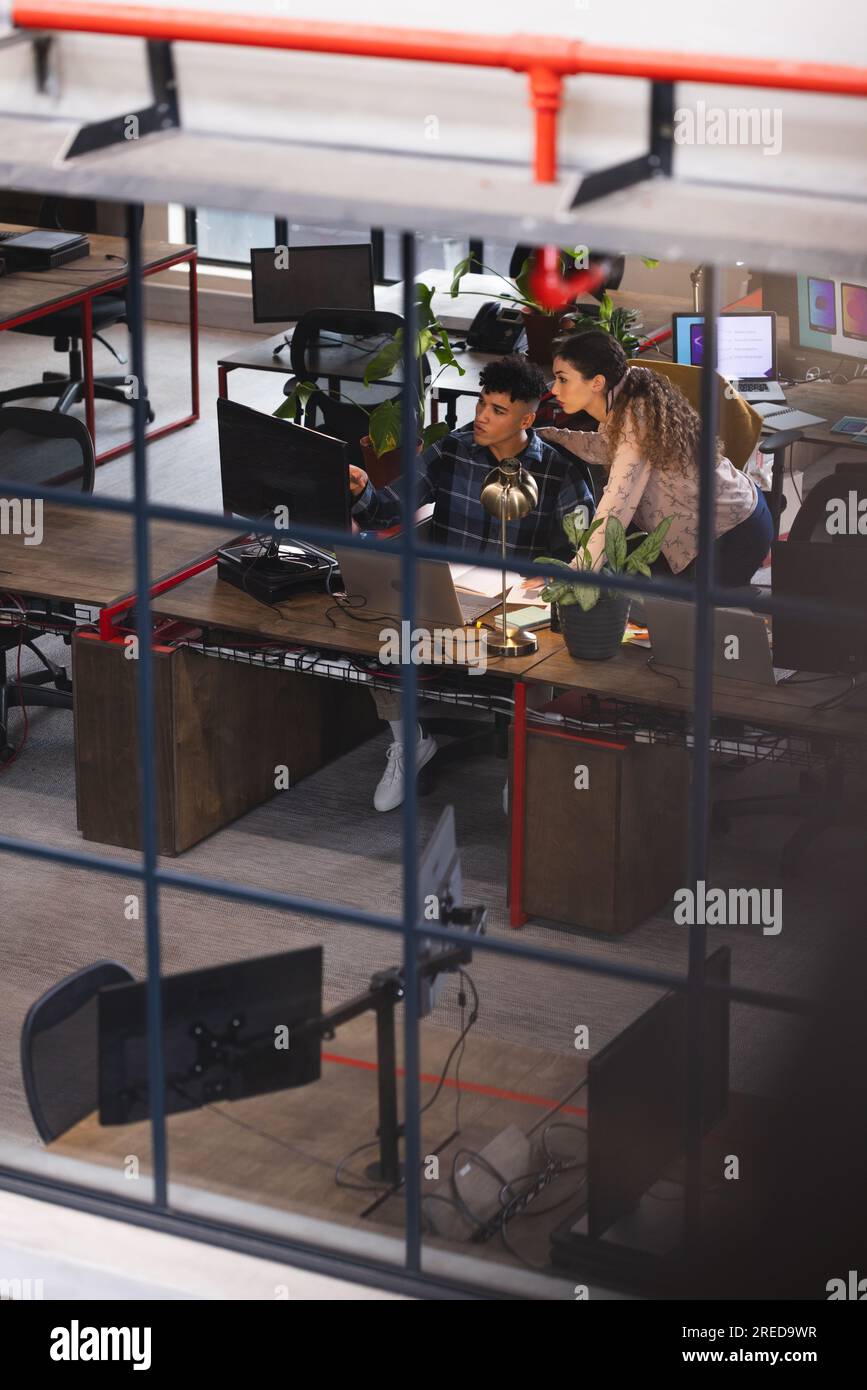 Busy diverse male and female colleagues in discussion at computer in ...