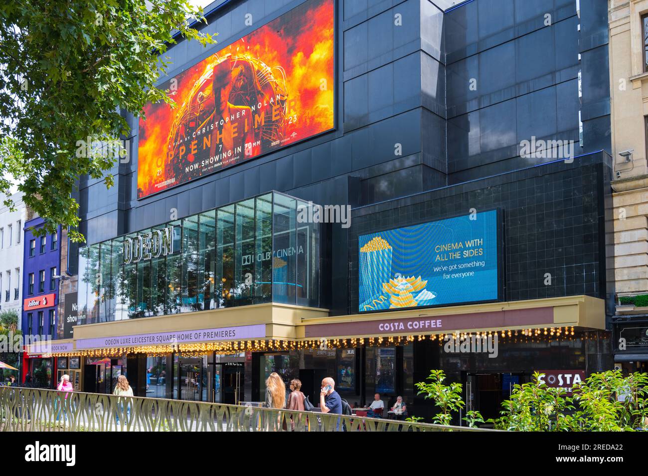 People out and about in Leicester Square pass by the Odeon Luxe cinema ...