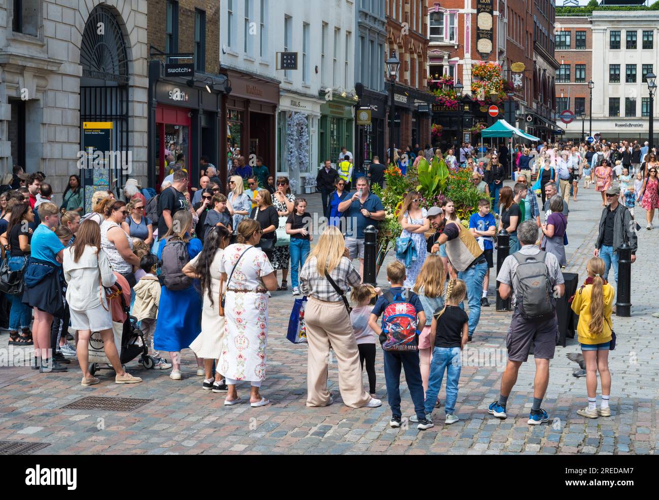 Crowd of people gathered to watch street entertainer. Covent Garden ...