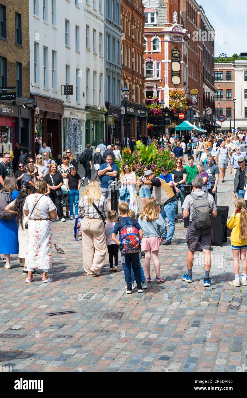 Crowd of people gathered to watch street entertainer. Covent Garden ...