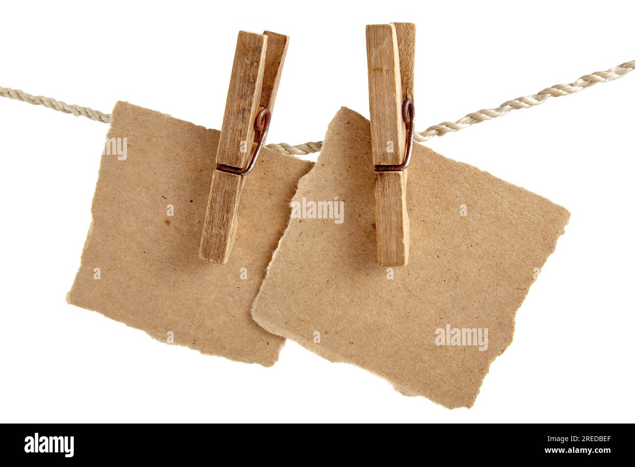 Two sheets of craft paper attached to a rope with clothespins isolated ...