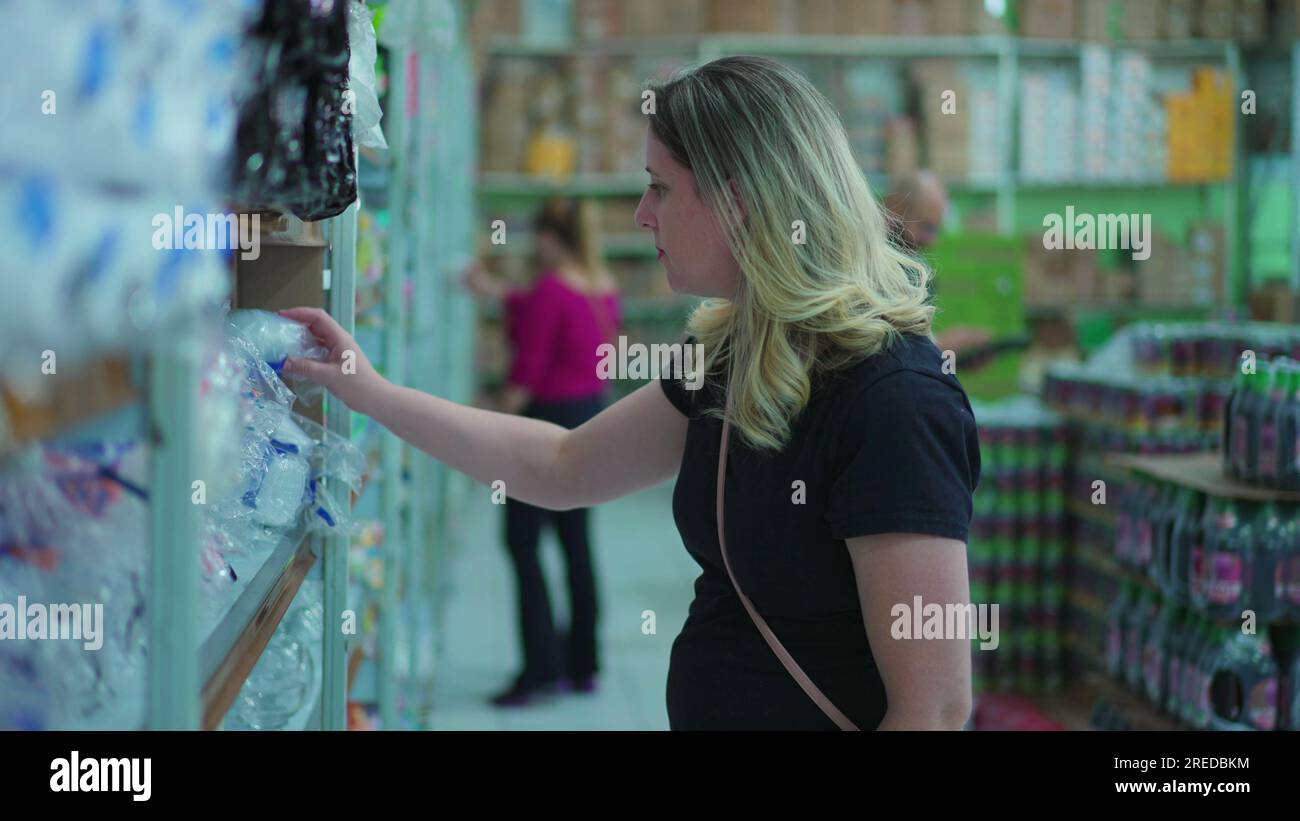 Female shopper browsing products at grocery store shelf. Woman ...