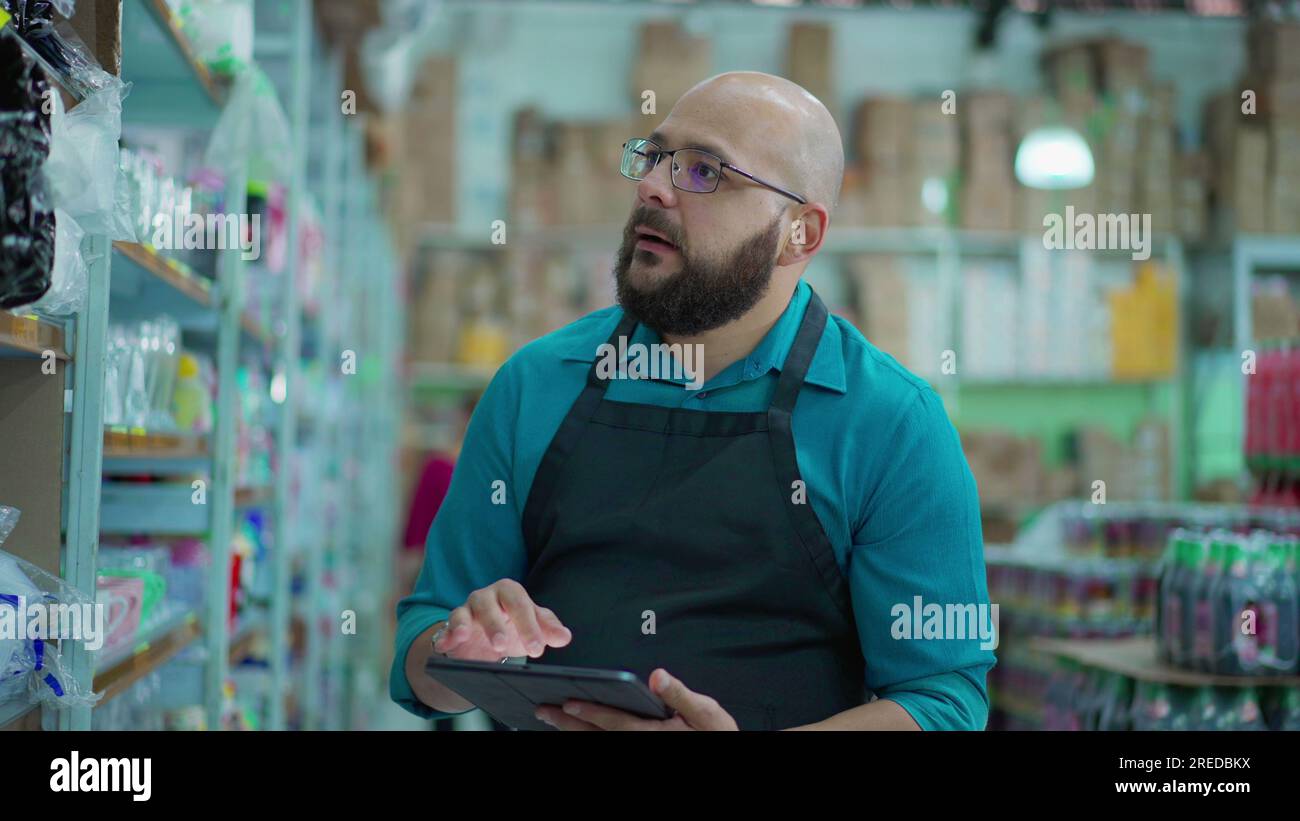 Grocery Store Employee Inspecting Products Using Tablet in Aisle ...