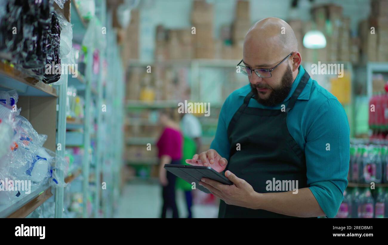 Grocery Store Employee Inspecting Products Using Tablet in Aisle ...