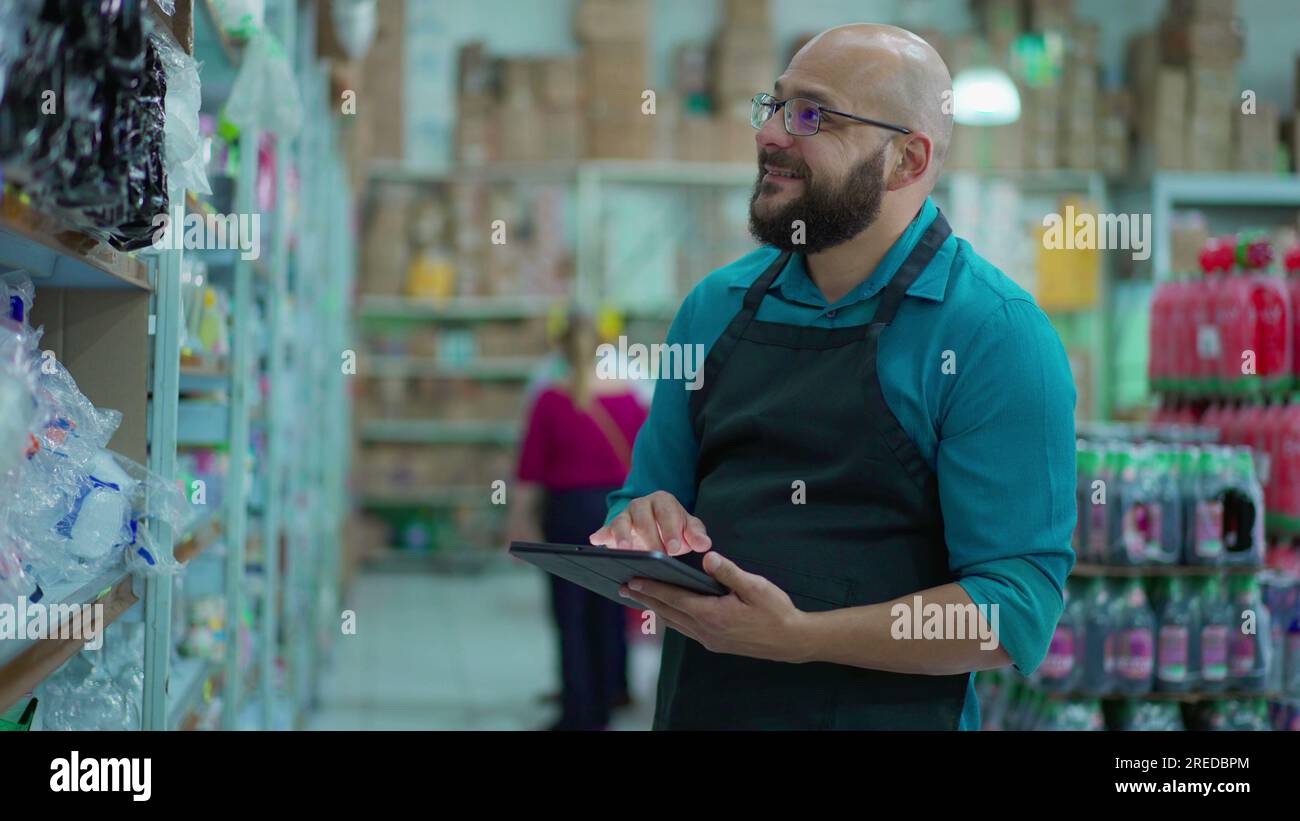 Grocery Store Employee Inspecting Products Using Tablet in Aisle ...