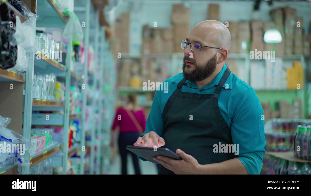 Grocery Store Employee Inspecting Products Using Tablet in Aisle ...