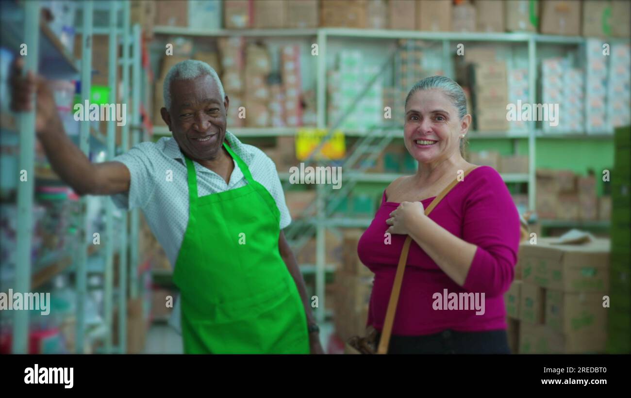 Happy African American employee and female customer laughing and ...