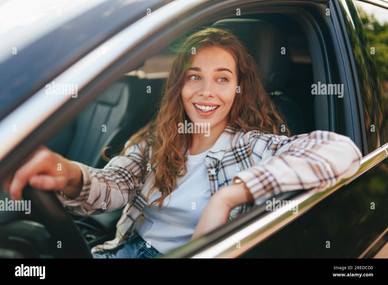 Happy smiling woman inside a car driving in the street Stock Photo - Alamy