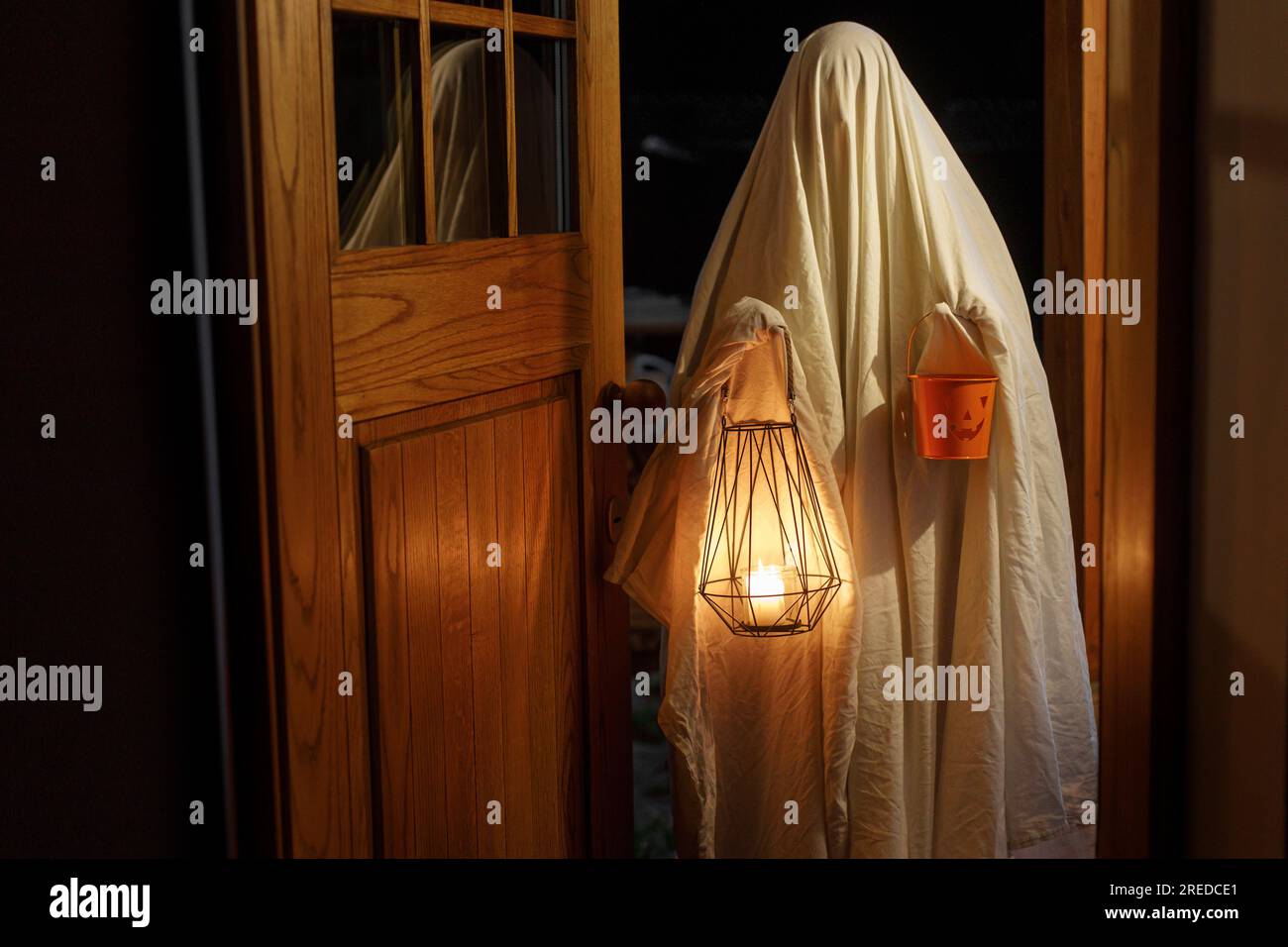 Trick or treat! Spooky ghost holding glowing lantern and halloween ...