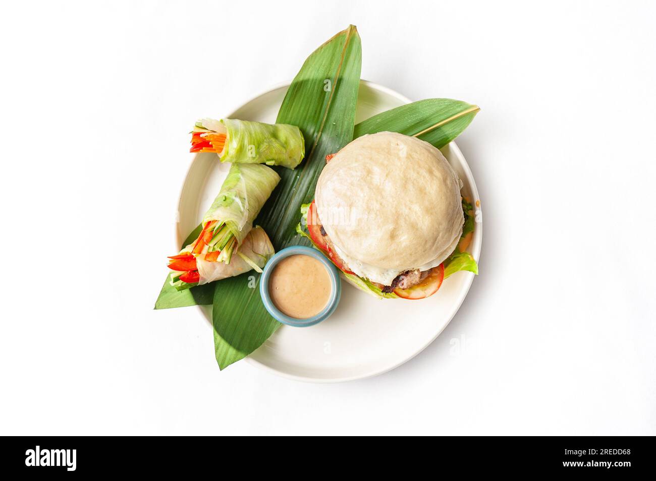 Burger with Bao steamed buns, spring rolls and sesame sauce Stock Photo ...