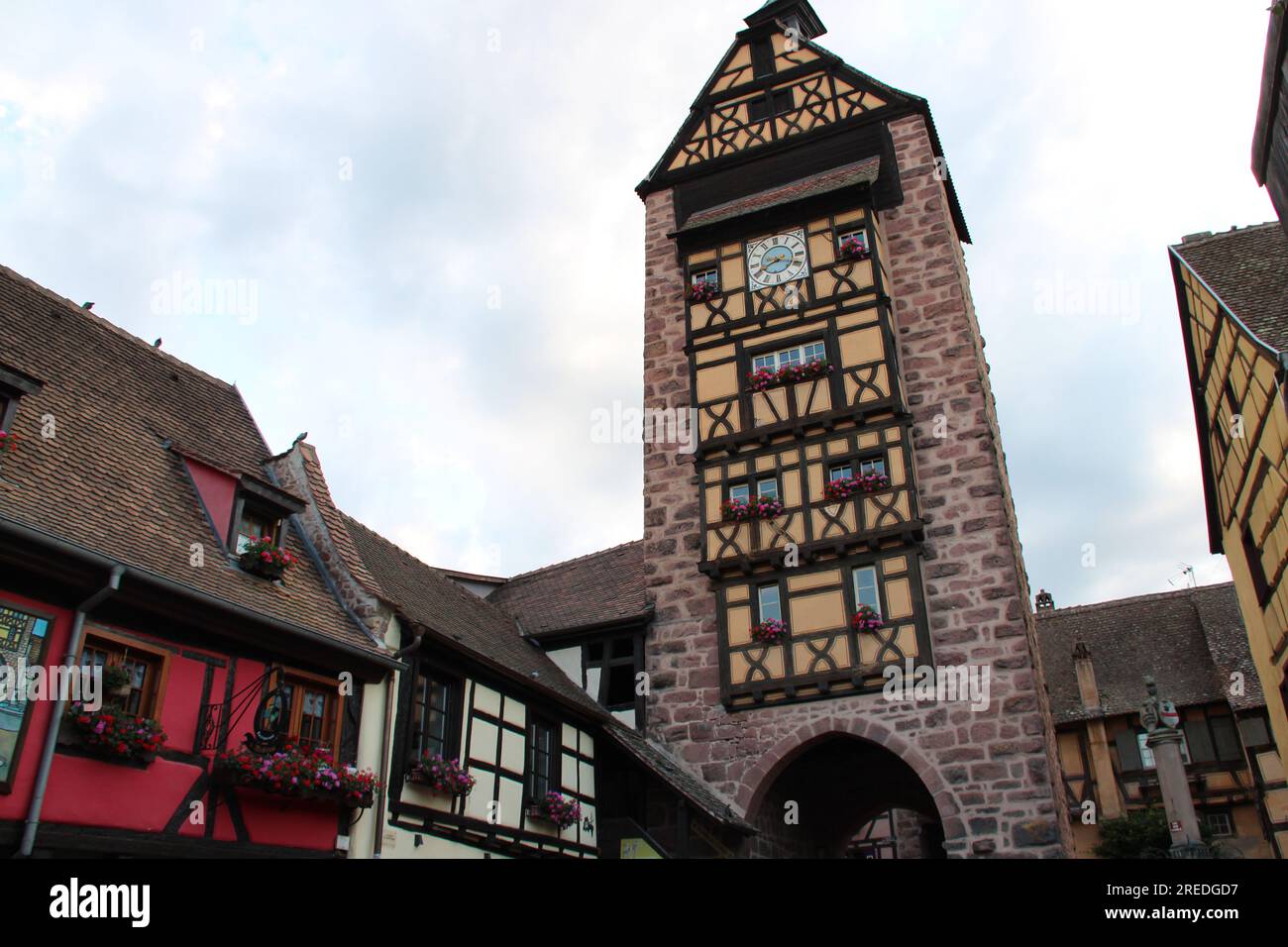 medieval tower (dolder) and half-timbered houses in riquewihr in alsace ...