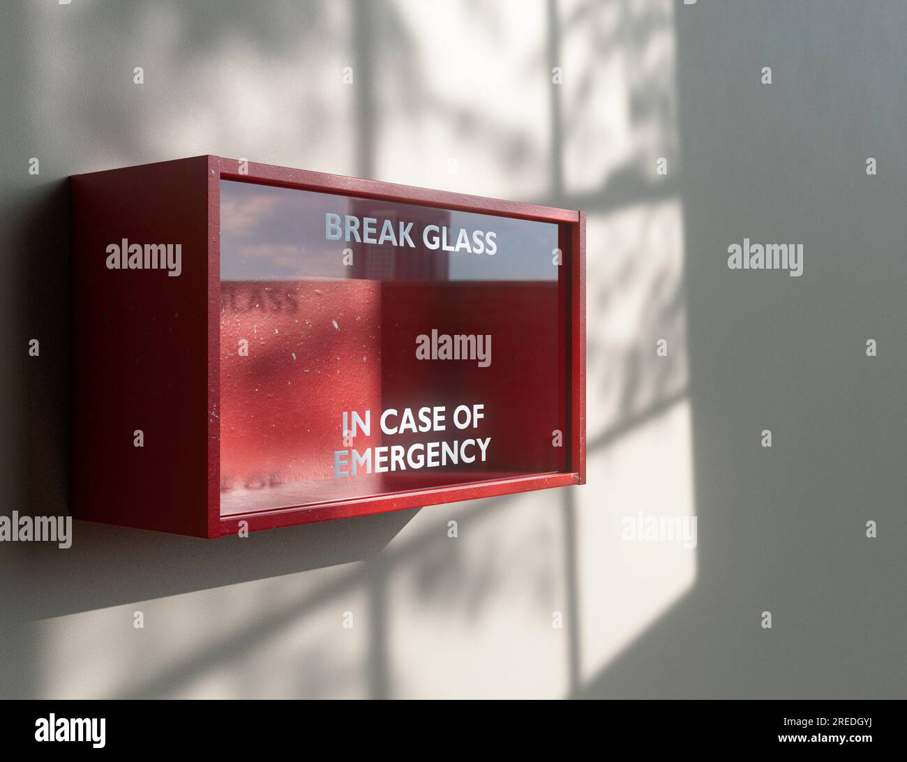 An empty red emergency box with an in case of emergency breakable glass ...