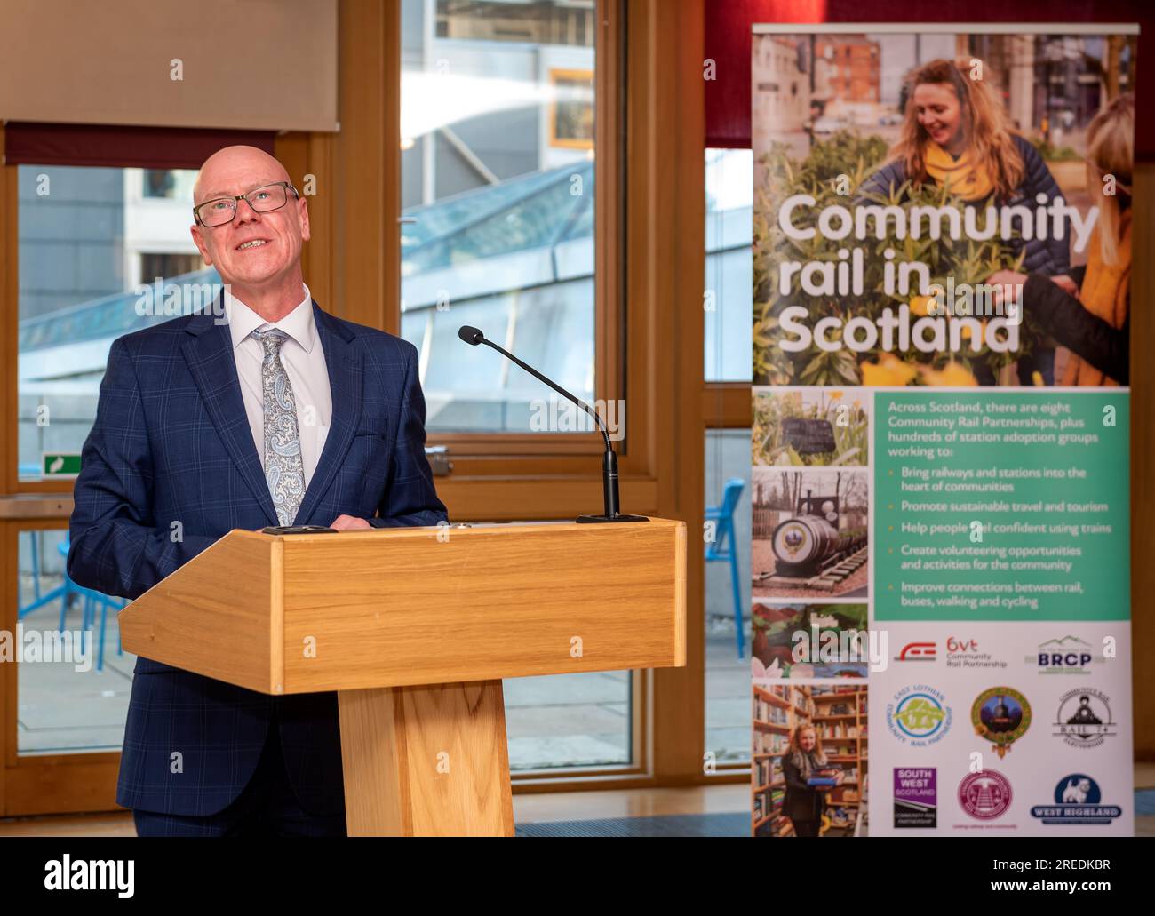 Kevin Stewart from Transport Minister and SNP MSP speaks from a podium ...