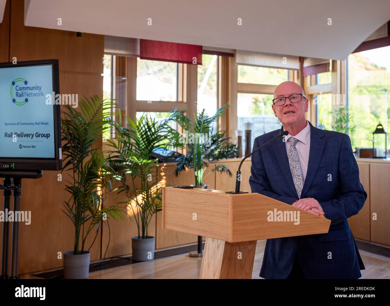 Kevin Stewart from Transport Minister and SNP MSP speaks from a podium ...