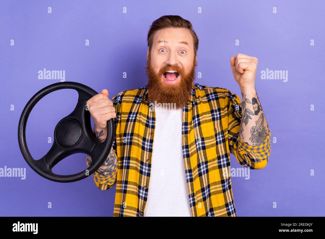Photo of positive overjoyed man arm hold wheel raise fist achievement ...