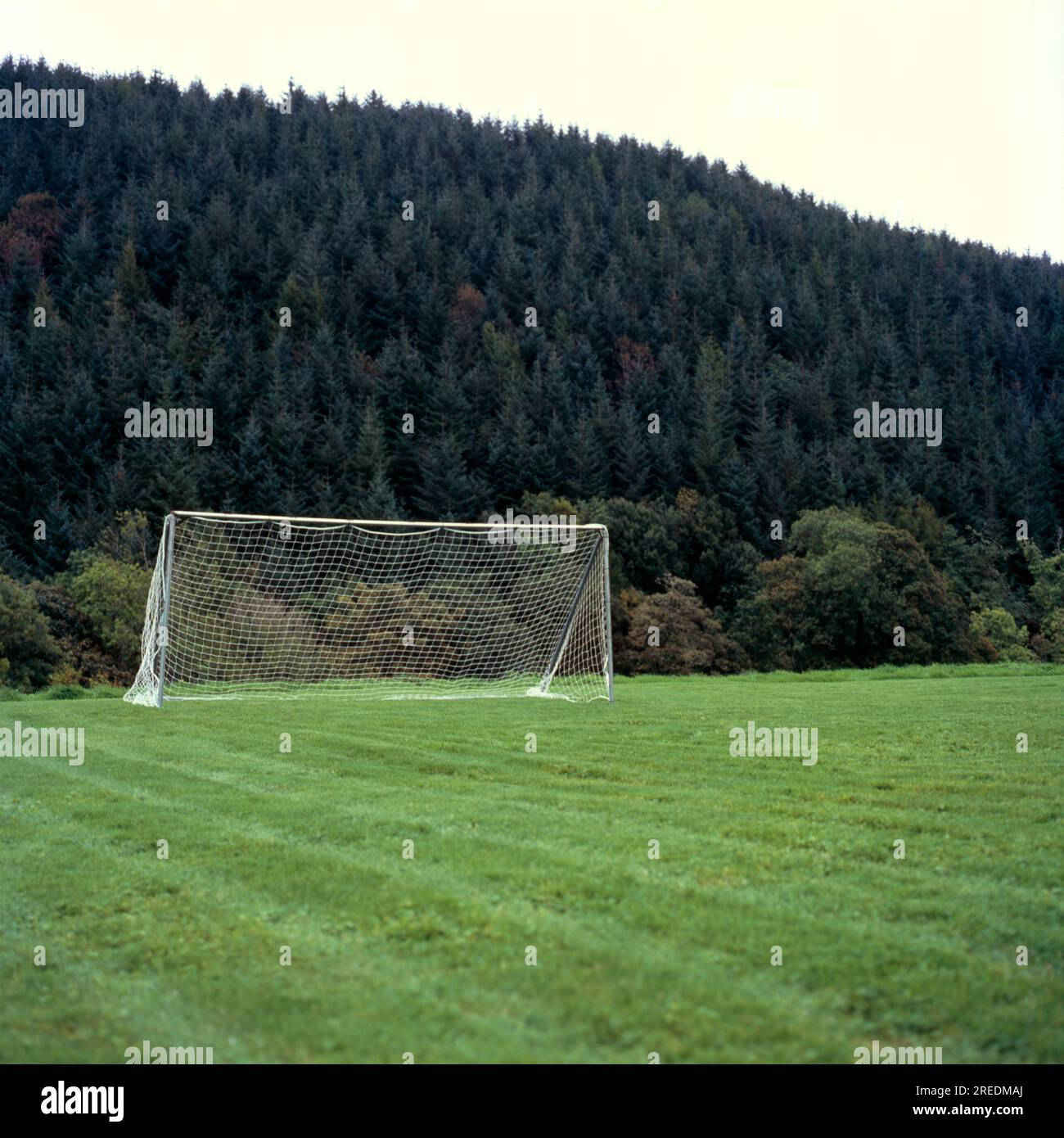 An empty goal post on a remote football field sits at the foot of a ...