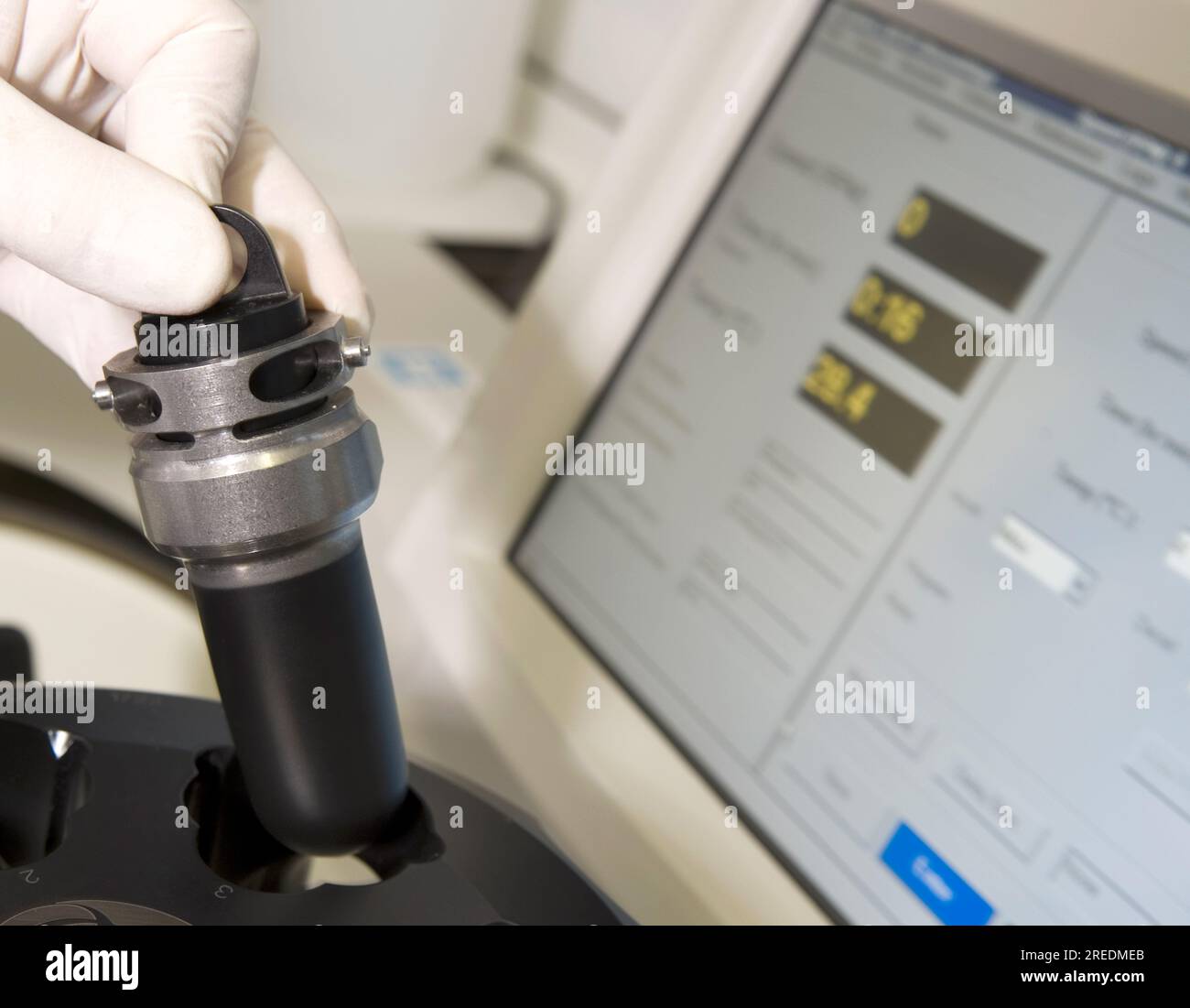 A scientist with white protective gloves pulls a module from a ...