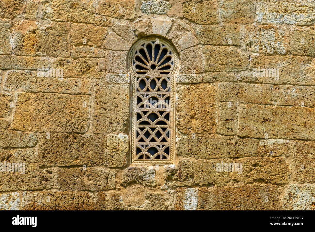 Keyhole window in the wall. Exterior of Visigothic church of San Juan ...