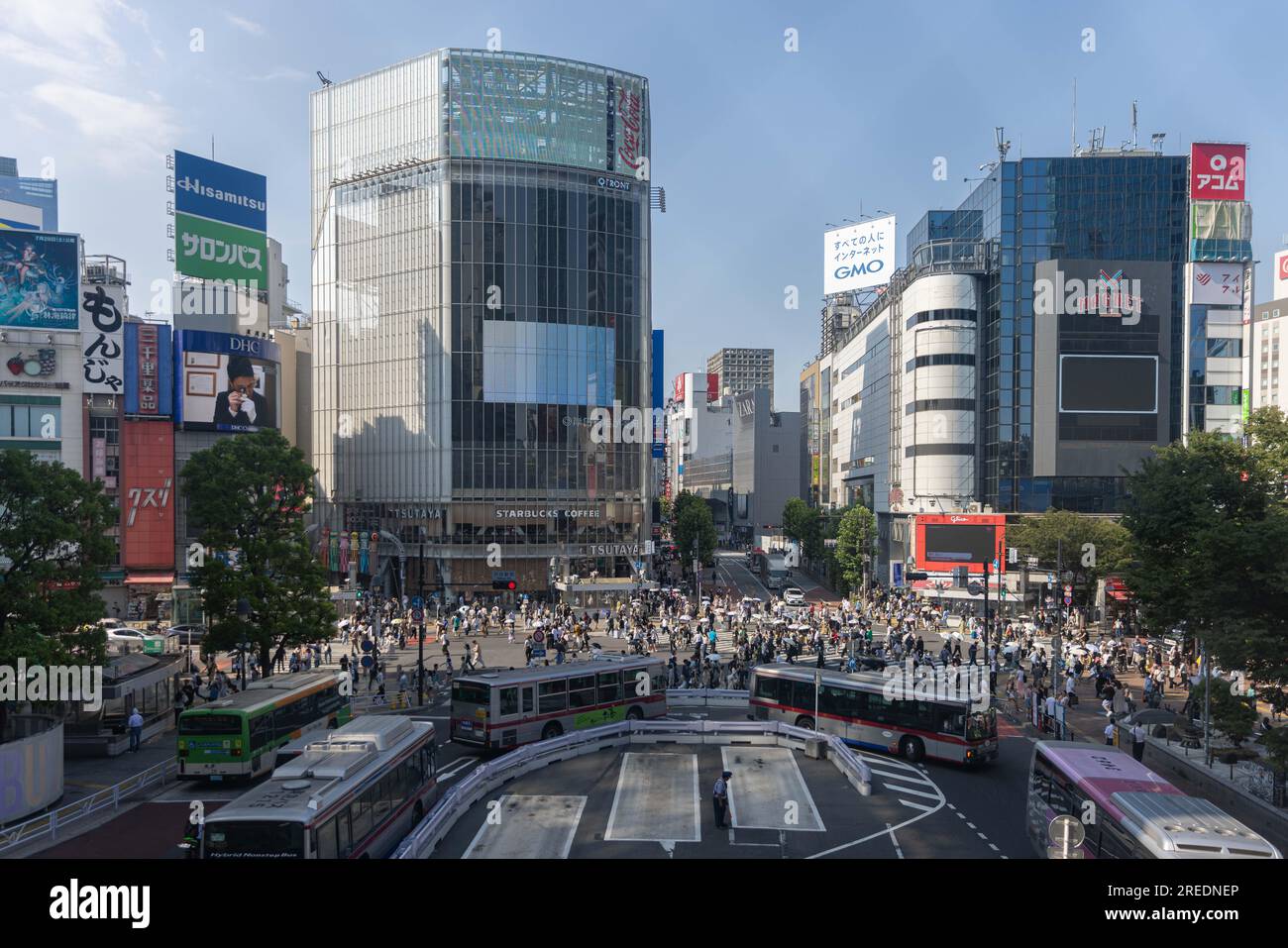 Pedestrians walk over Shibuya crossing during a sunny day, when ...