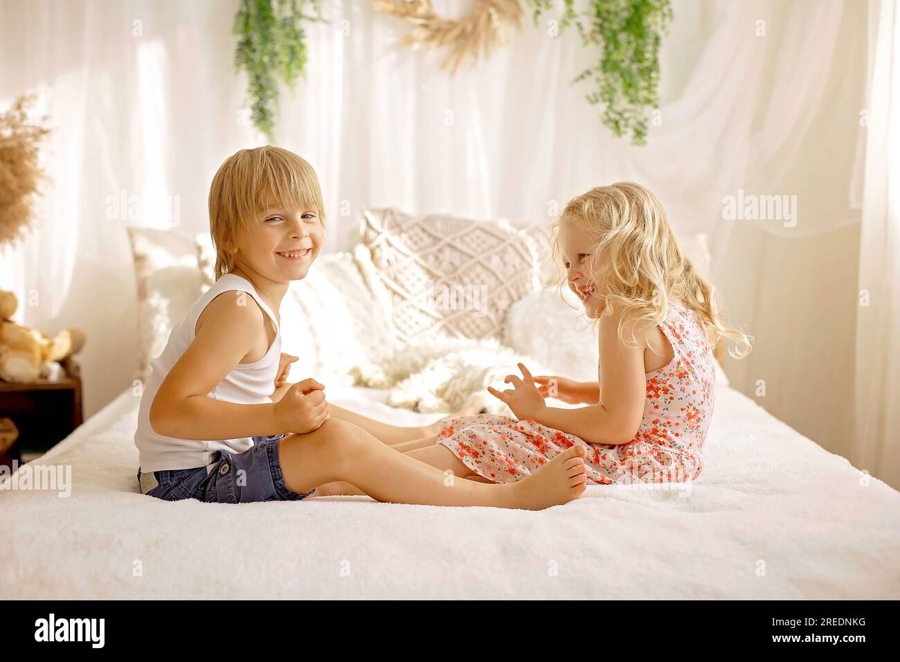 Cute sweet toddler children, tickling feet on the bed, laughing and ...