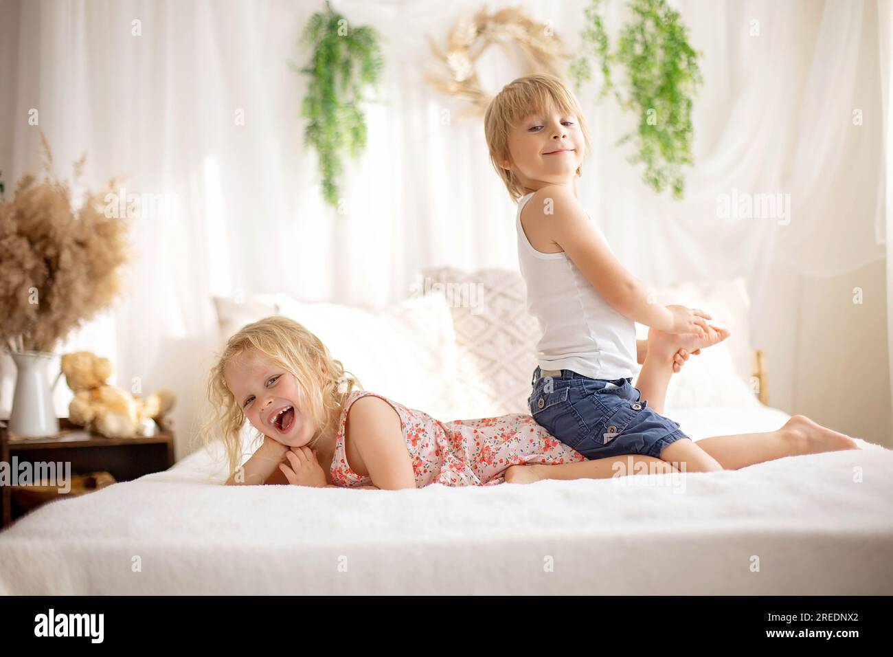 Cute sweet toddler children, tickling feet on the bed, laughing and ...
