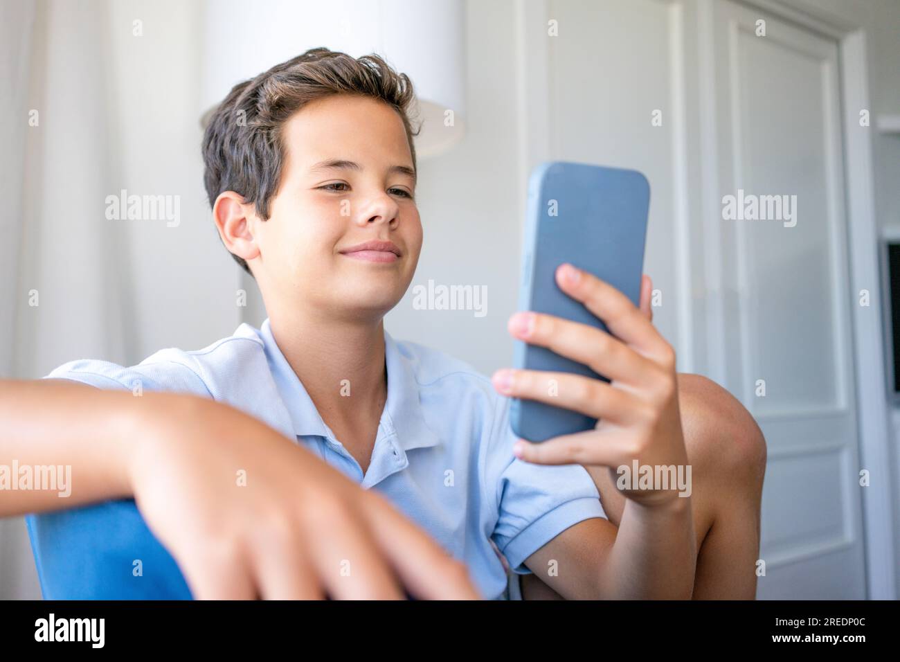 Boy using phone to play games. Little funny boy playing smartphone game ...