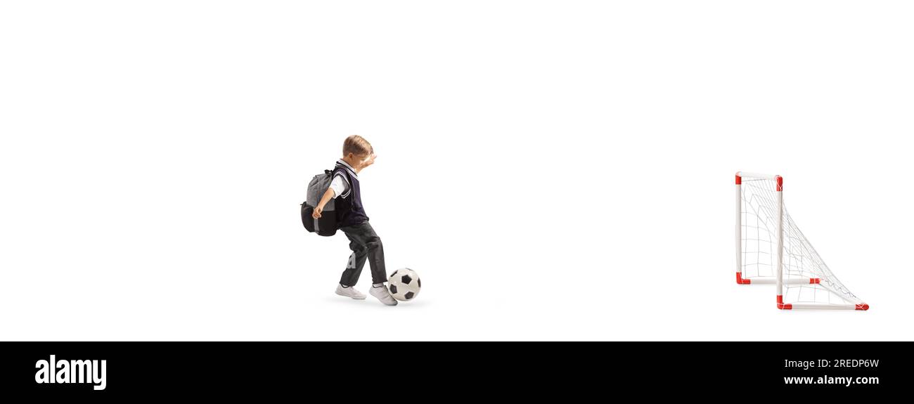 Schoolboy with a backpack kicking football isolated on white background ...